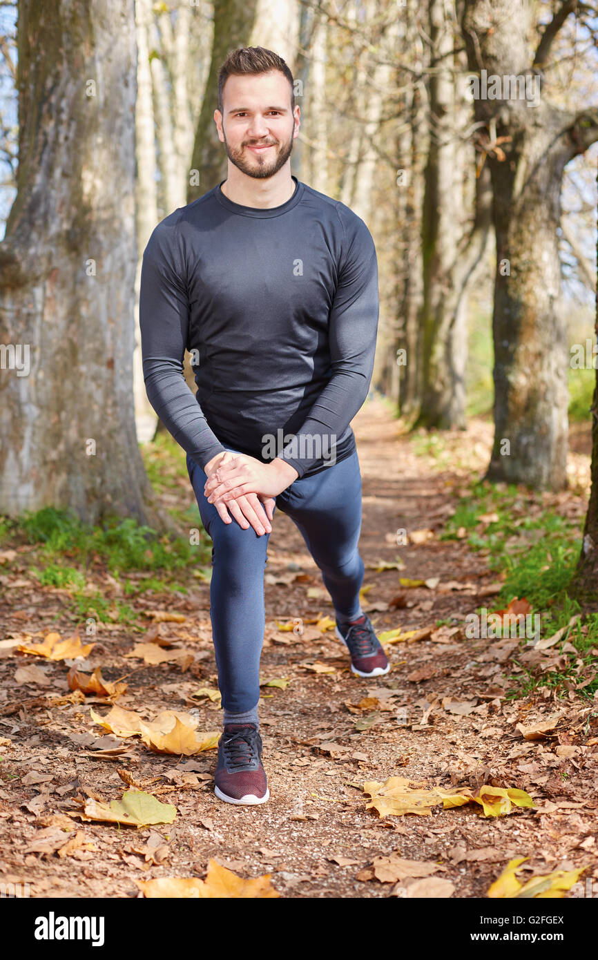 Runner doing stretching outside in autumn Stock Photo - Alamy