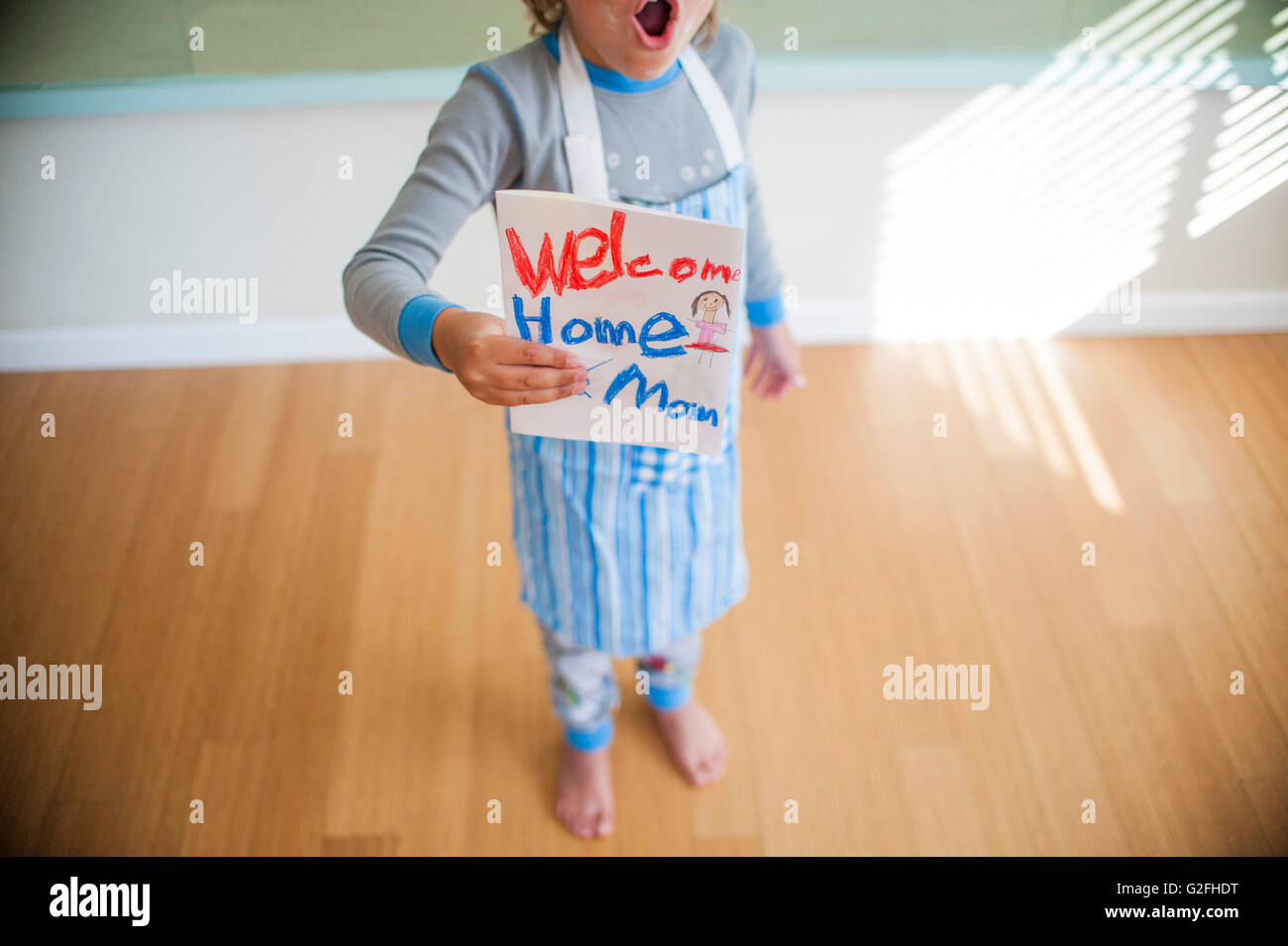 Young Boy in Pajamas and Apron Holding Welcome Home Mom Sign Stock ...
