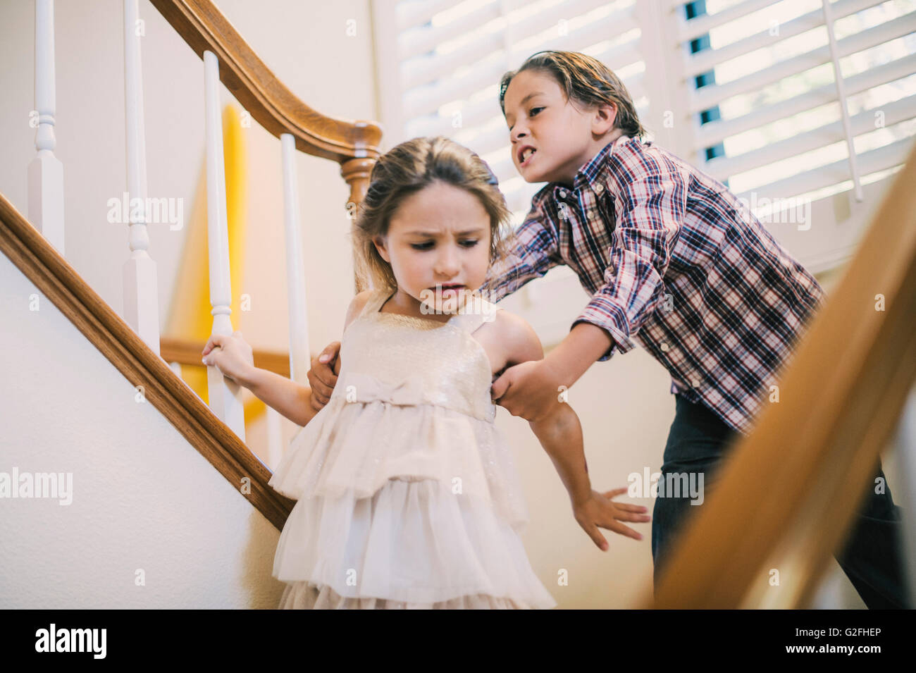 Boy Grabbing Girl's Arm on Stairs Stock Photo - Alamy