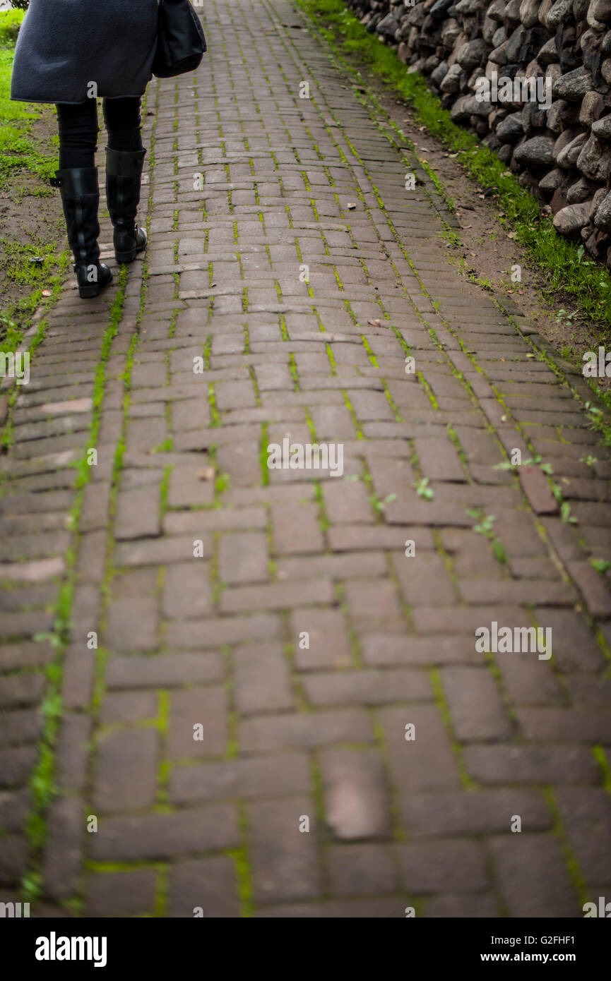 Woman Walking on Brick Pathway, Rear View Stock Photo - Alamy