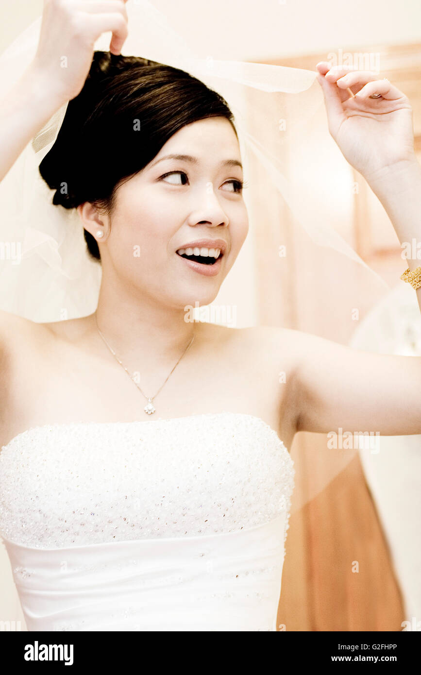Excited Bride Putting on Veil Stock Photo - Alamy