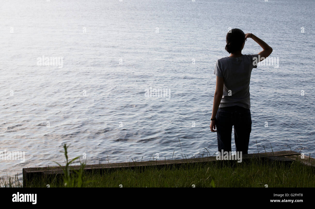 Teen Girl Looking into Distance Across Lake Stock Photo - Alamy