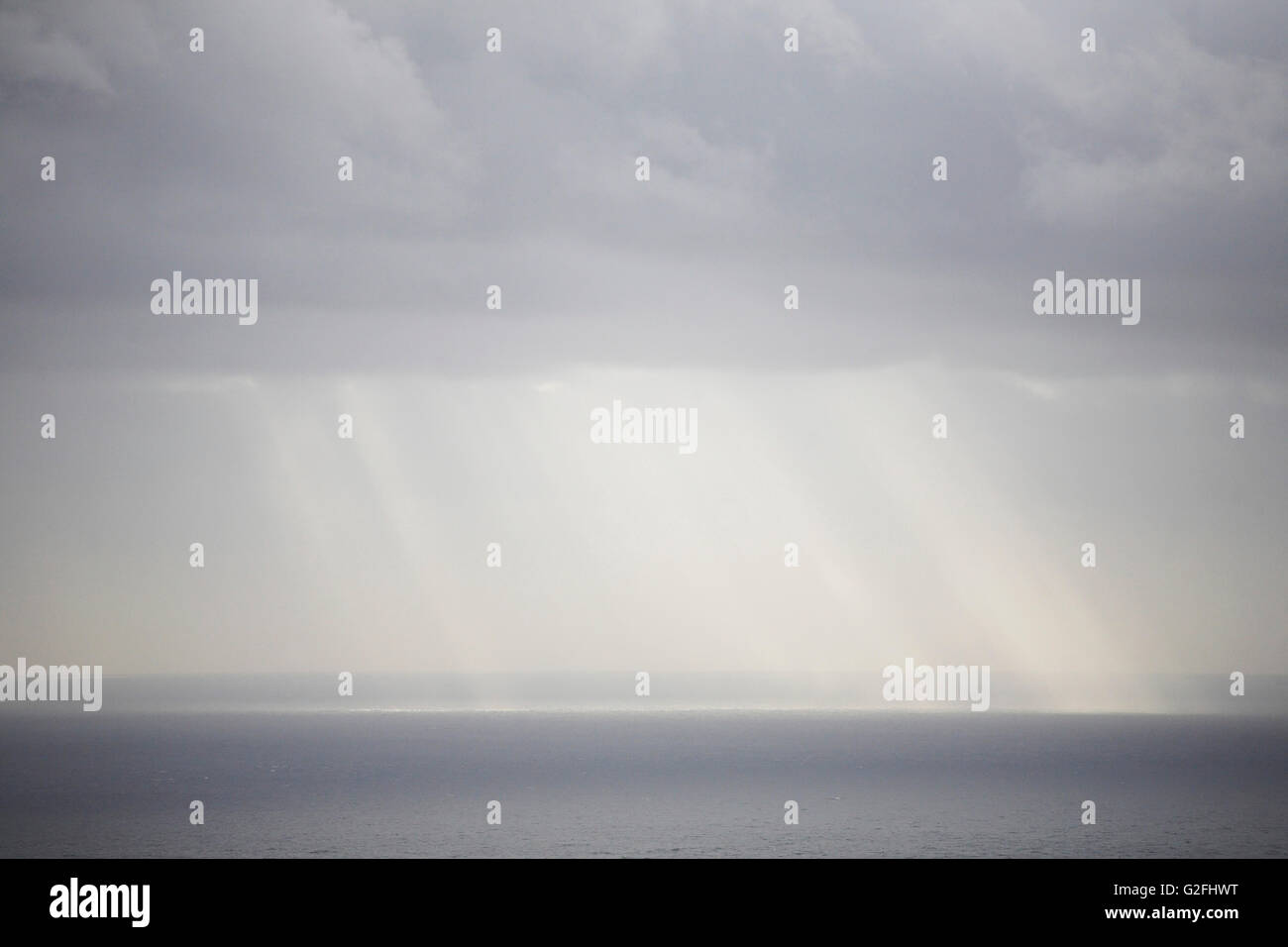 Sun Rays Reflected on Ocean Through Gray Clouds Stock Photo - Alamy