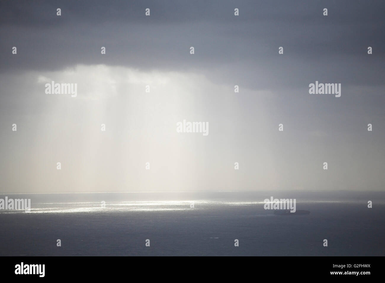 Sun Rays Reflected on Ocean Through Gray Clouds Stock Photo - Alamy