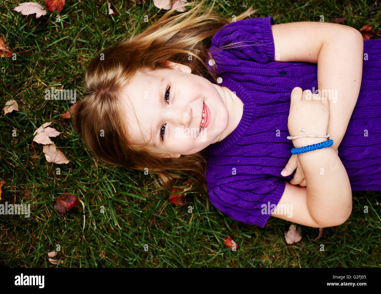 Smiling Young Girl Laying on Ground Stock Photo - Alamy