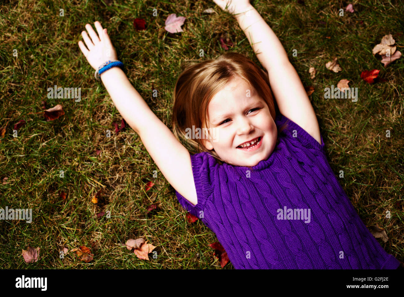 Young Smiling Girl Laying on Ground Stock Photo - Alamy