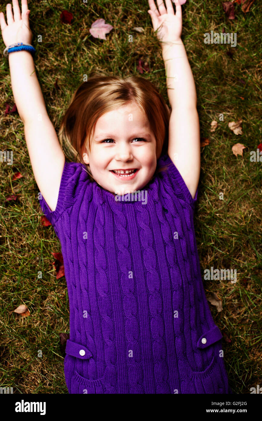 Young Smiling Girl Laying on Ground Stock Photo - Alamy