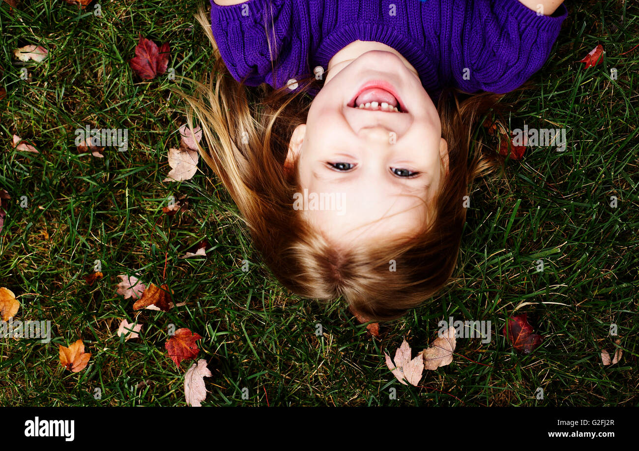 Young Smiling Girl Laying on Ground Stock Photo - Alamy