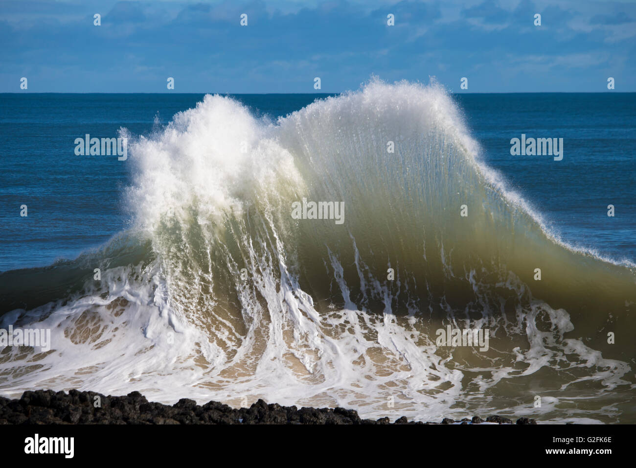 Frothy foaming white backwash from the Indian Ocean waves breaking on ...