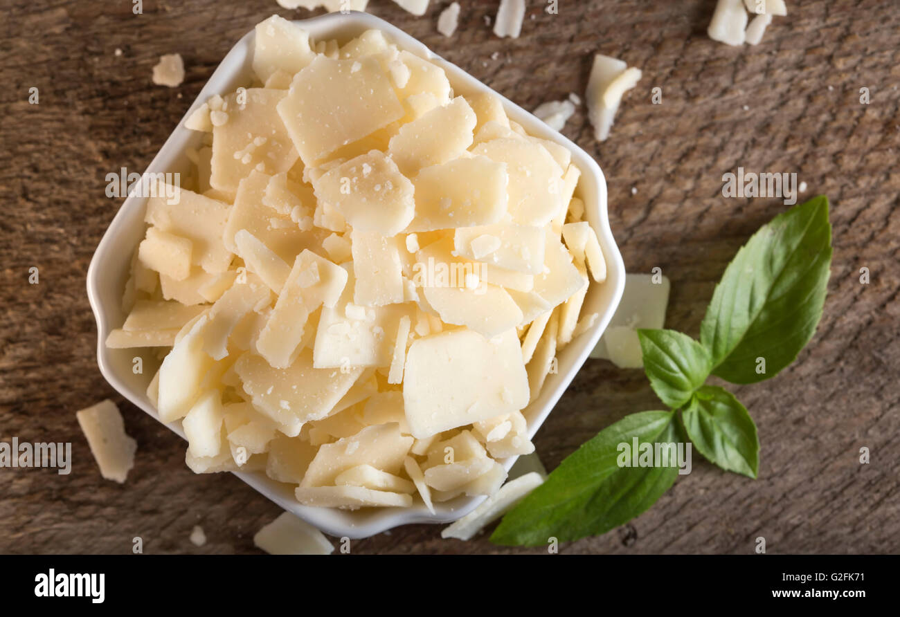 Bowl with parmesan cheese flakes on rustic table Stock Photo - Alamy