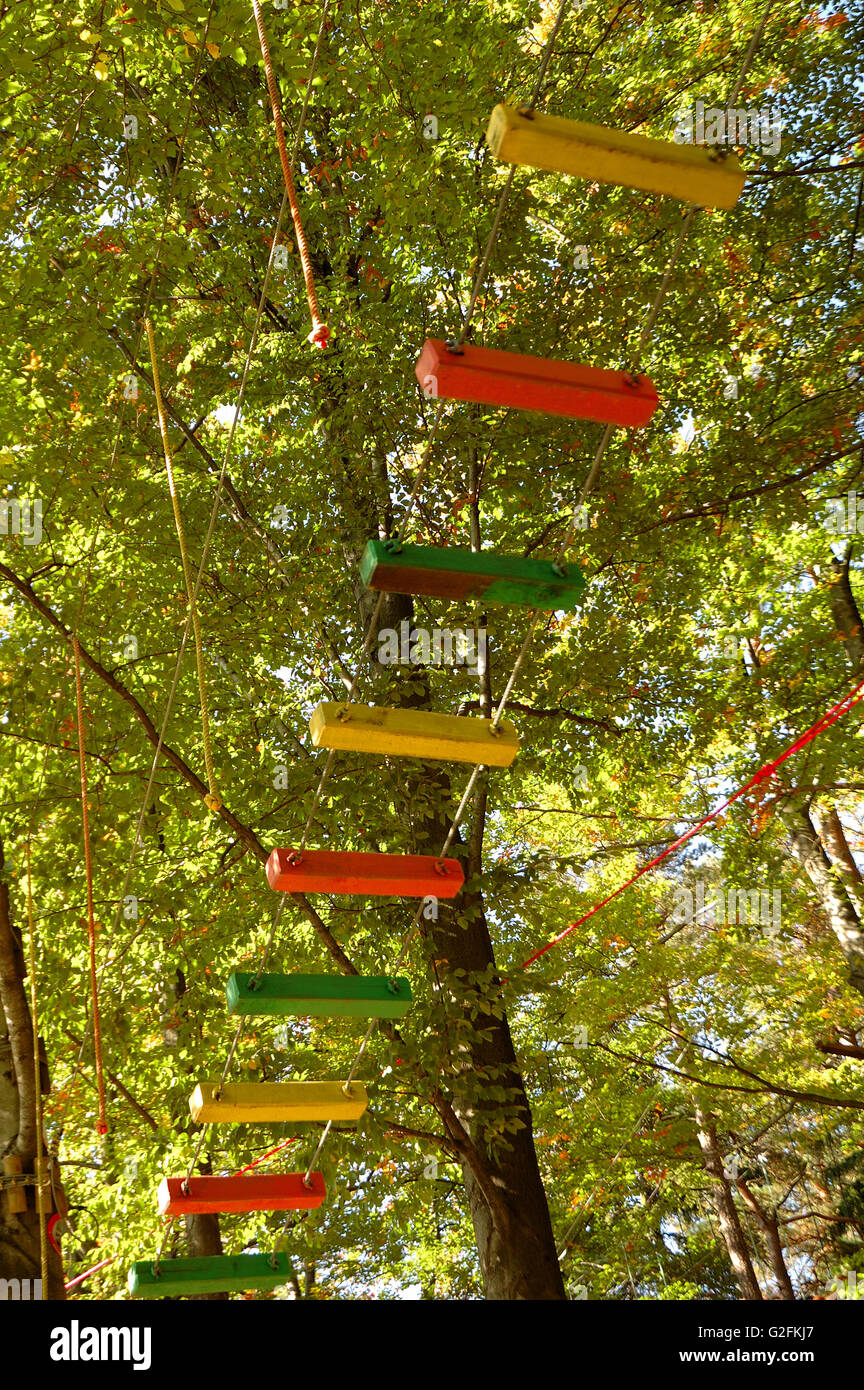 Bridge made of colourful logs and ropes in ropes course Stock Photo - Alamy