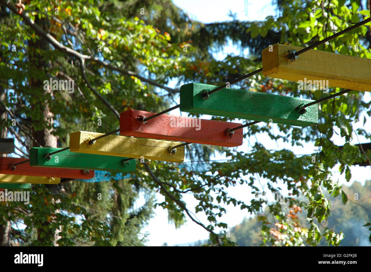 Bridge made of colourful logs and ropes in ropes course Stock Photo - Alamy