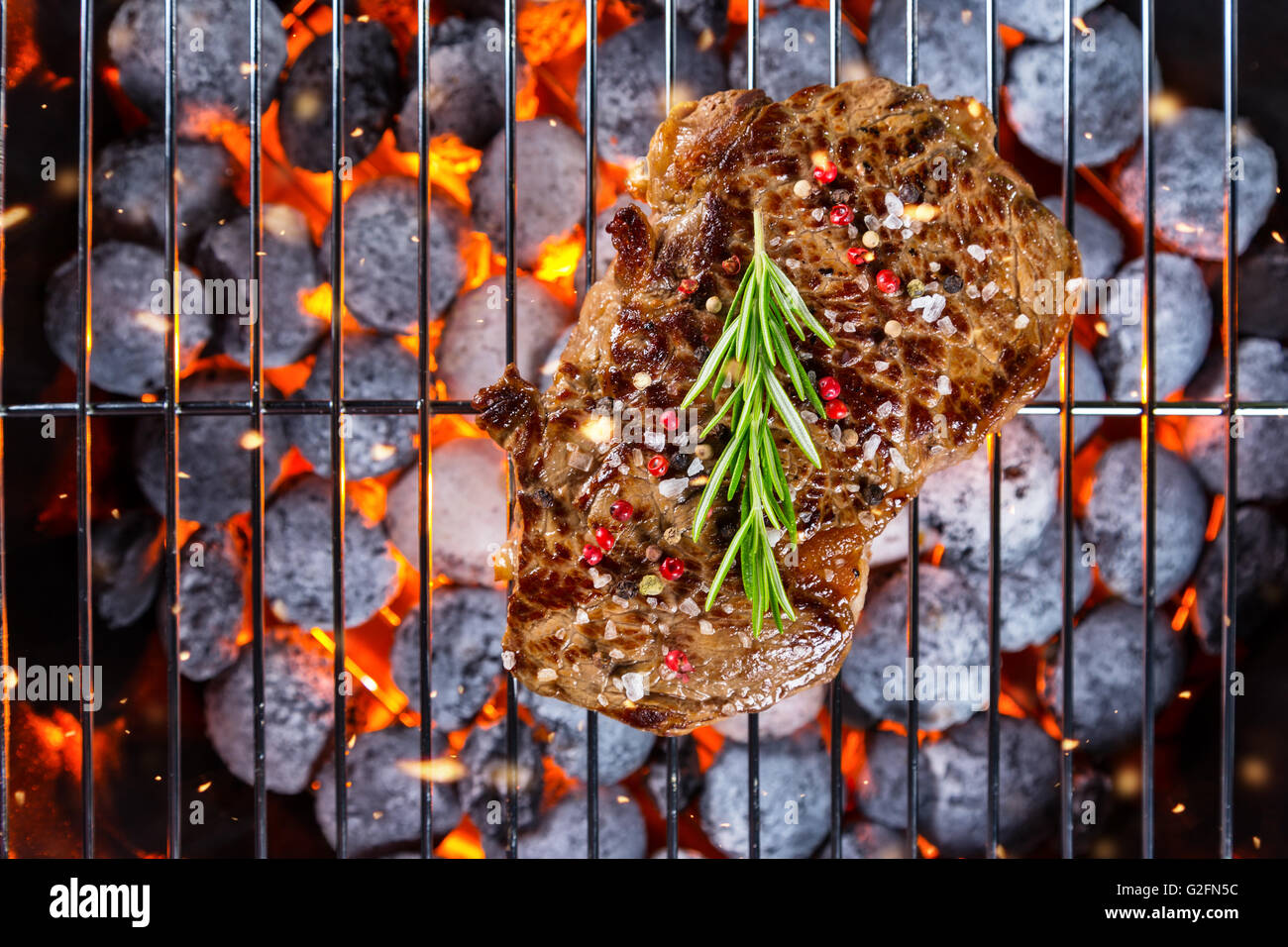 Beef steak on grill in fire, shot from above view Stock Photo - Alamy