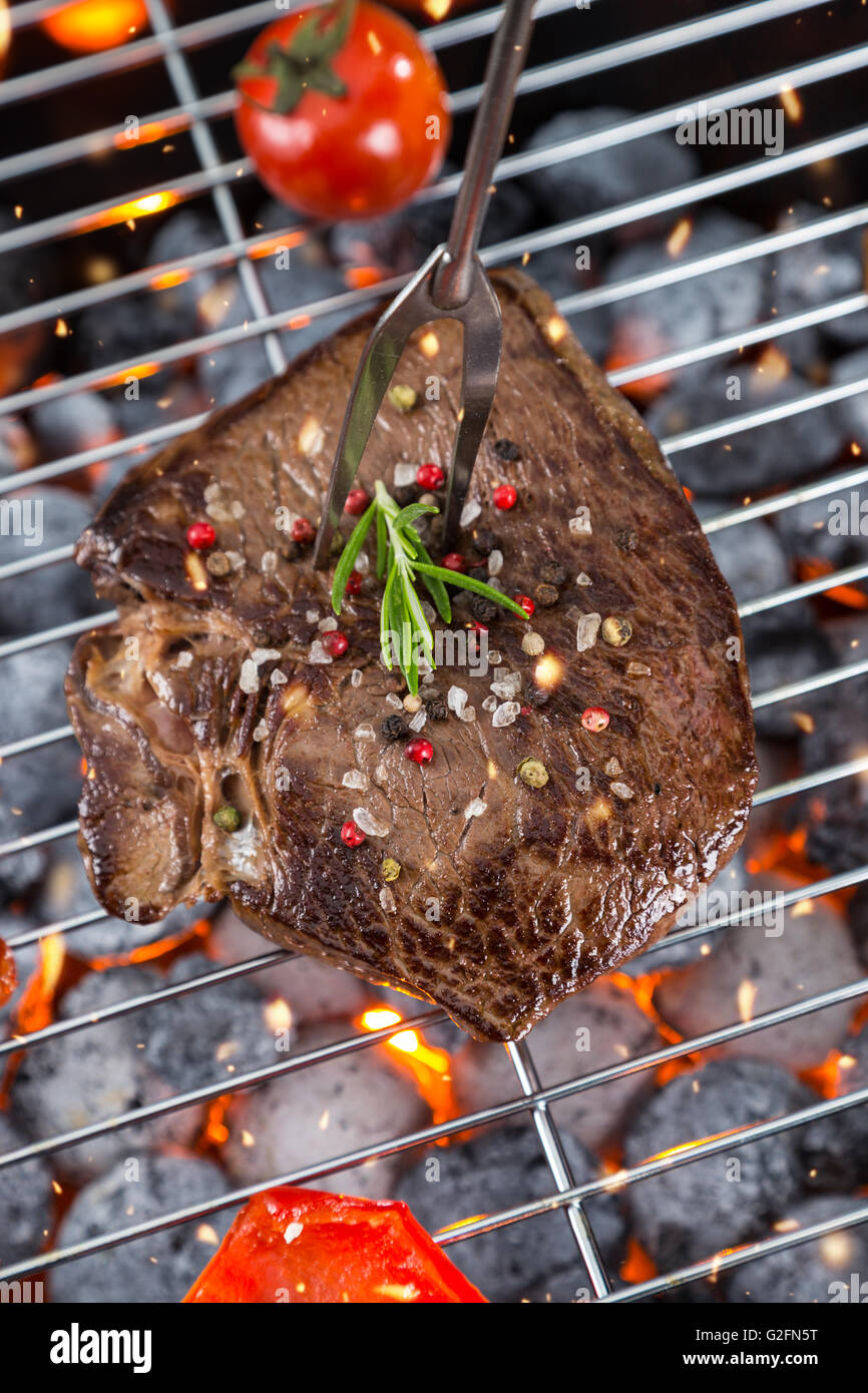 Beef steak on grill in fire, shot from above view Stock Photo - Alamy