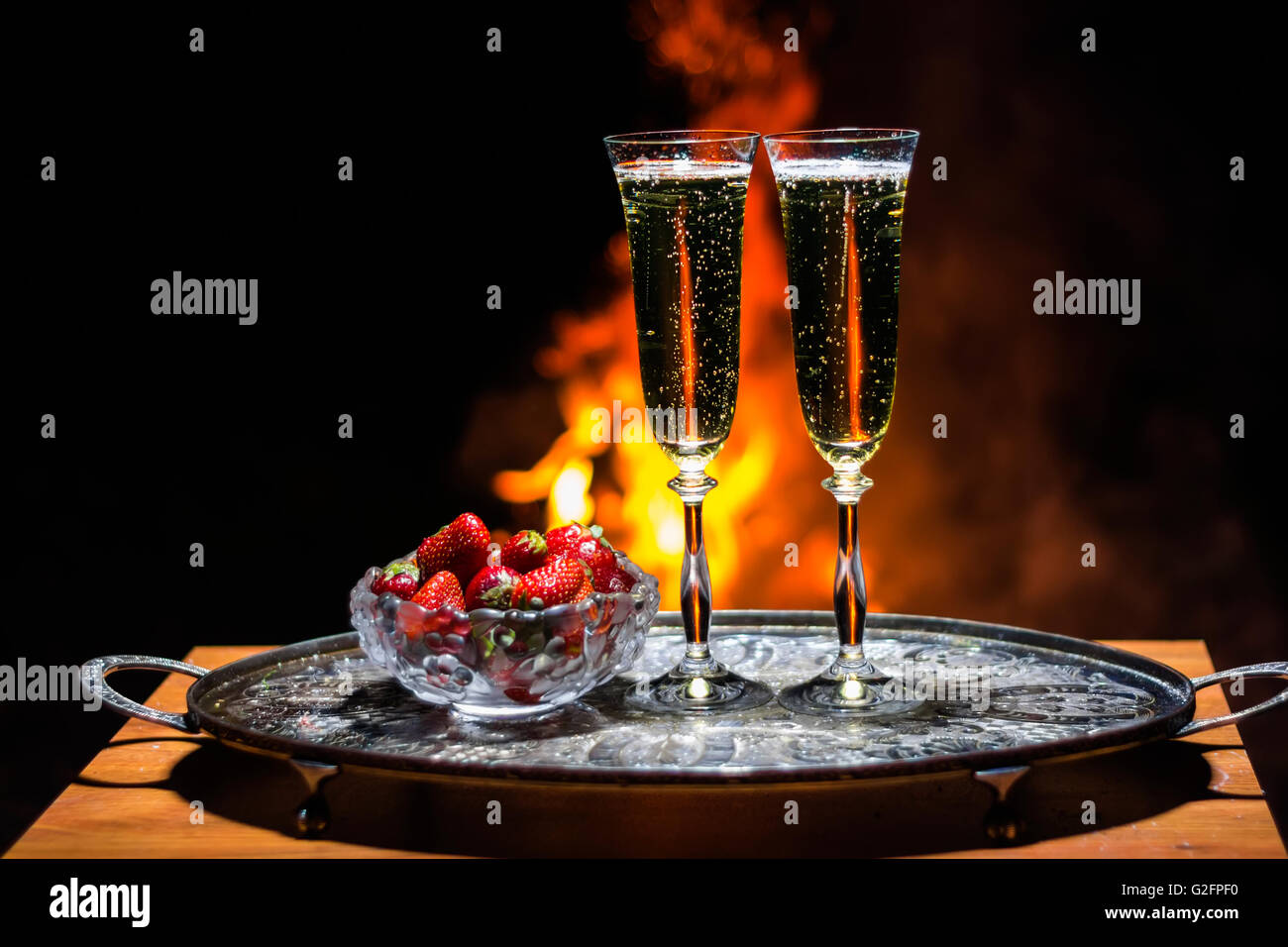 two glasses of champagne with flame on background Stock Photo - Alamy