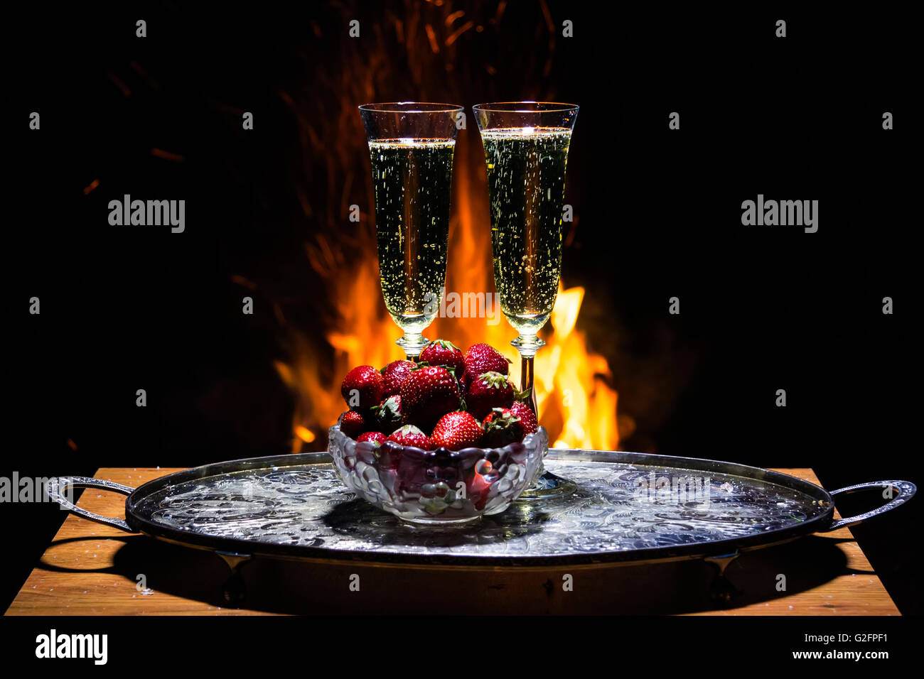 two glasses of champagne with flame on background Stock Photo - Alamy