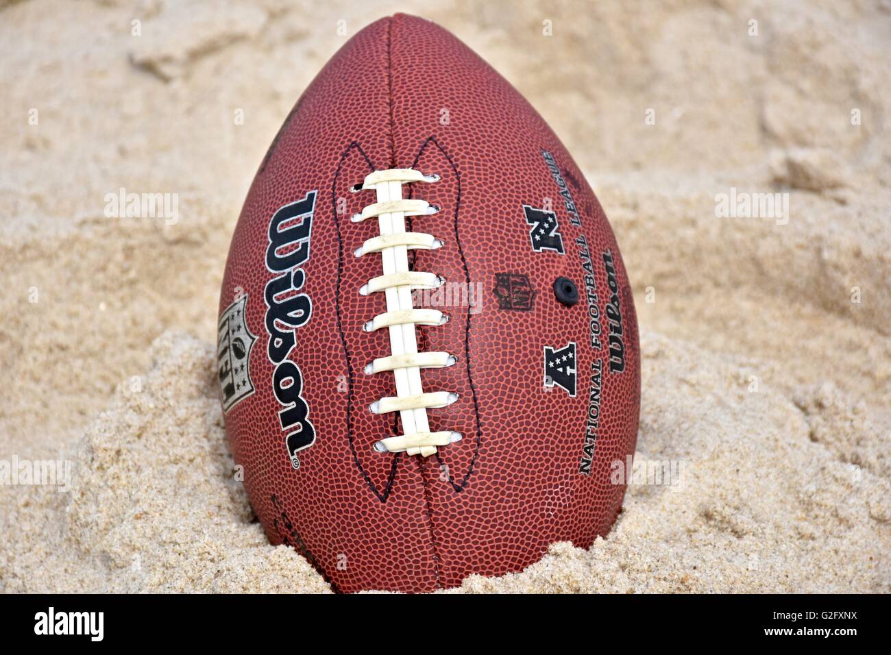 A Wilson football in the sand on the beach Stock Photo - Alamy