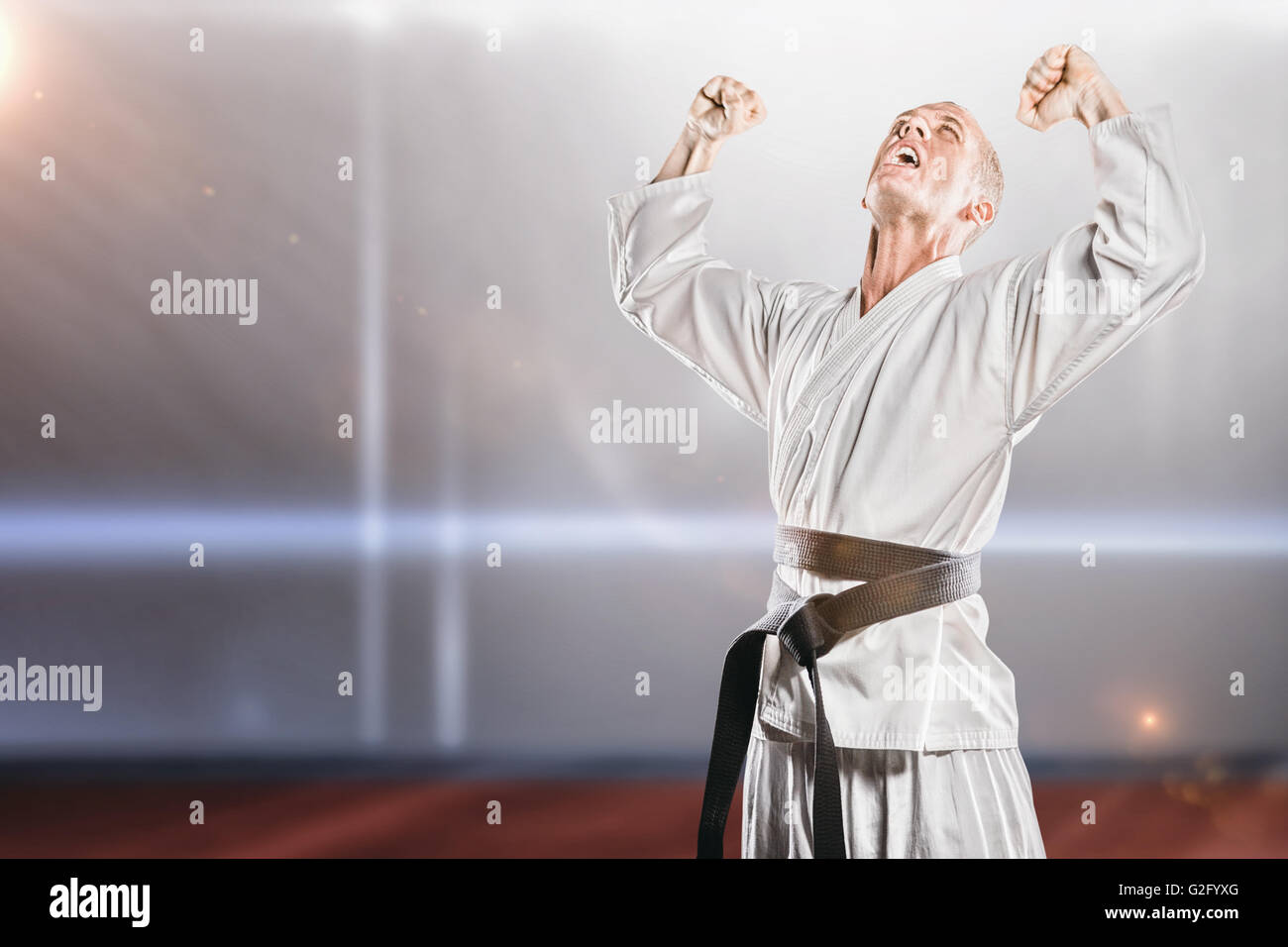 Composite image of fighter posing after victory Stock Photo - Alamy