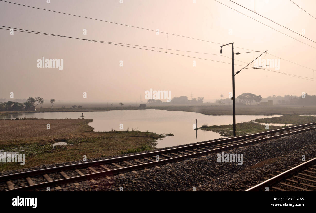 Indian countryside as viewed from the footboard of a running train ...