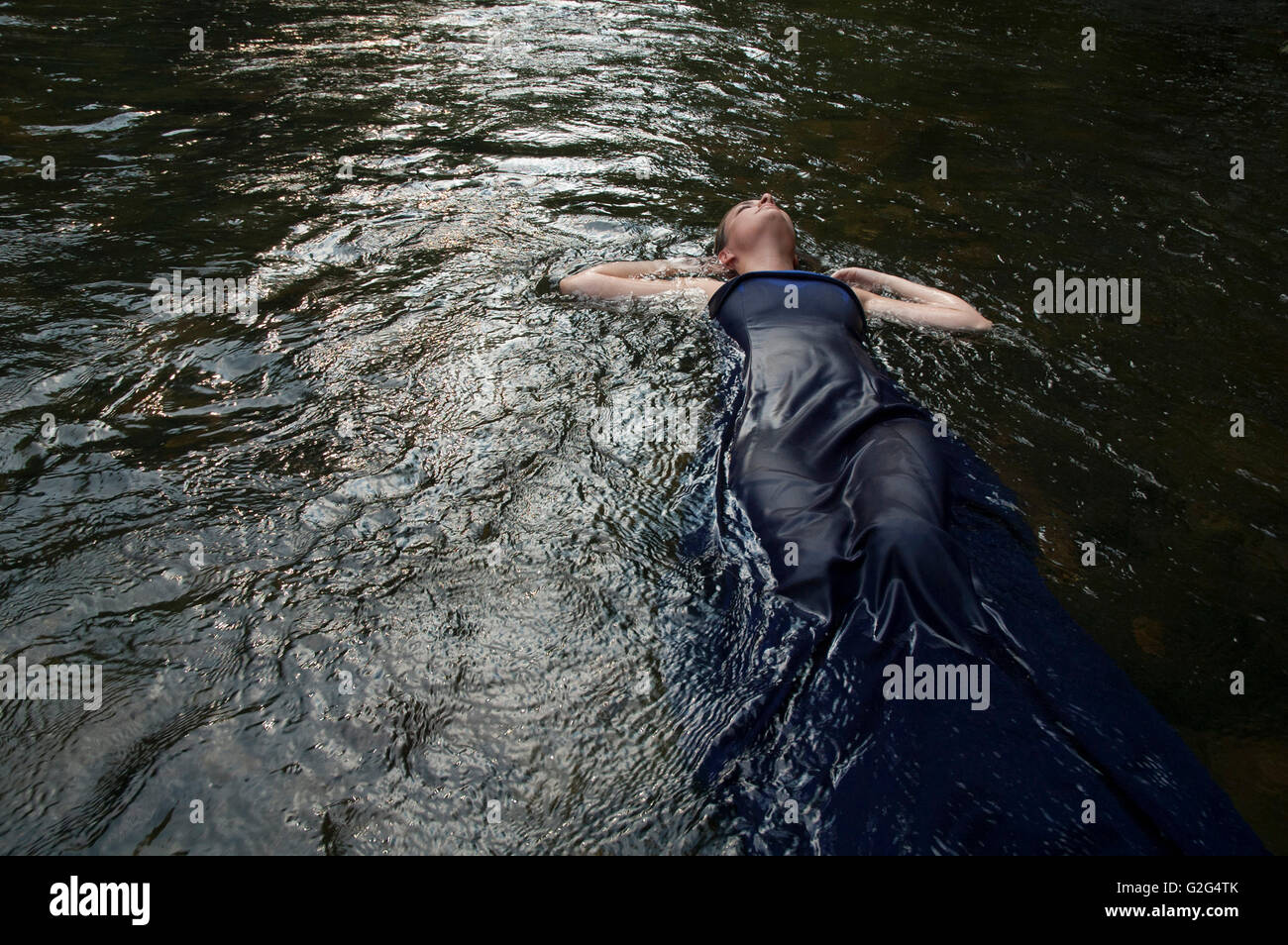 Young Adult Woman in Long Blue Dress Floating on Back in River Stock ...
