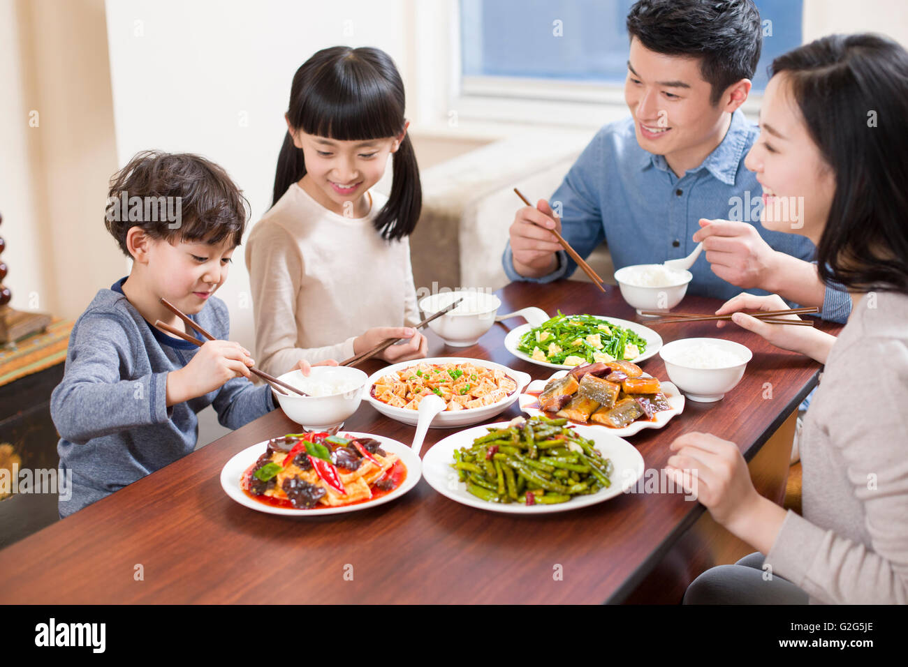Happy young family having lunch Stock Photo - Alamy
