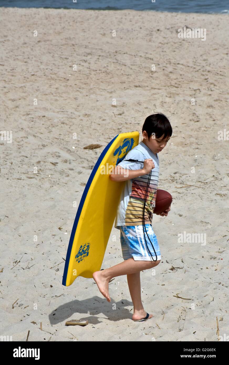 A boy boogie boarding while at the beach Stock Photo - Alamy
