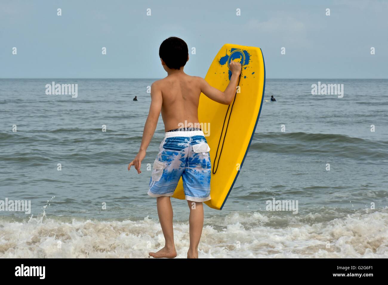 A boy boogie boarding while at the beach Stock Photo - Alamy