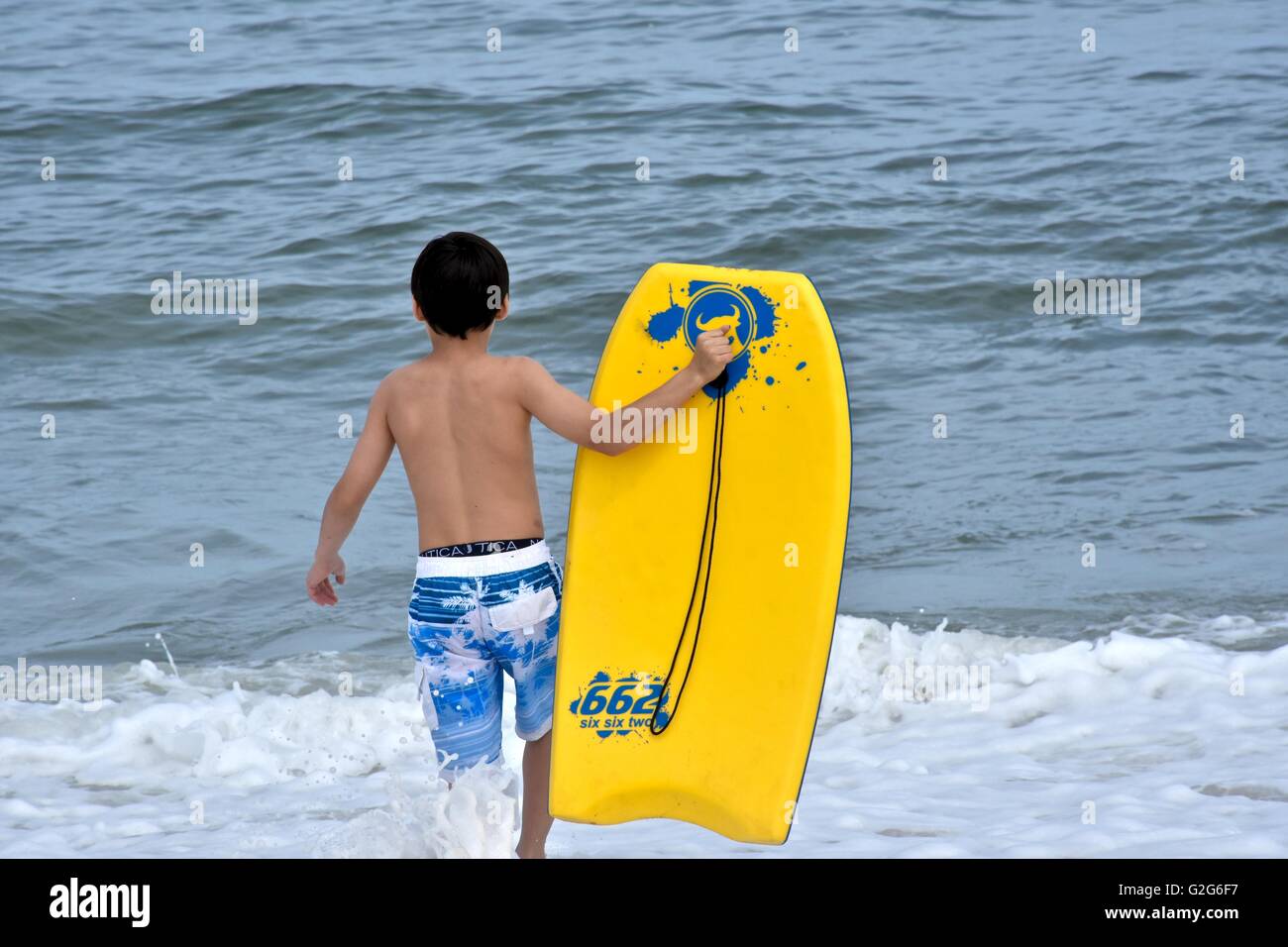 A boy boogie boarding while at the beach Stock Photo - Alamy