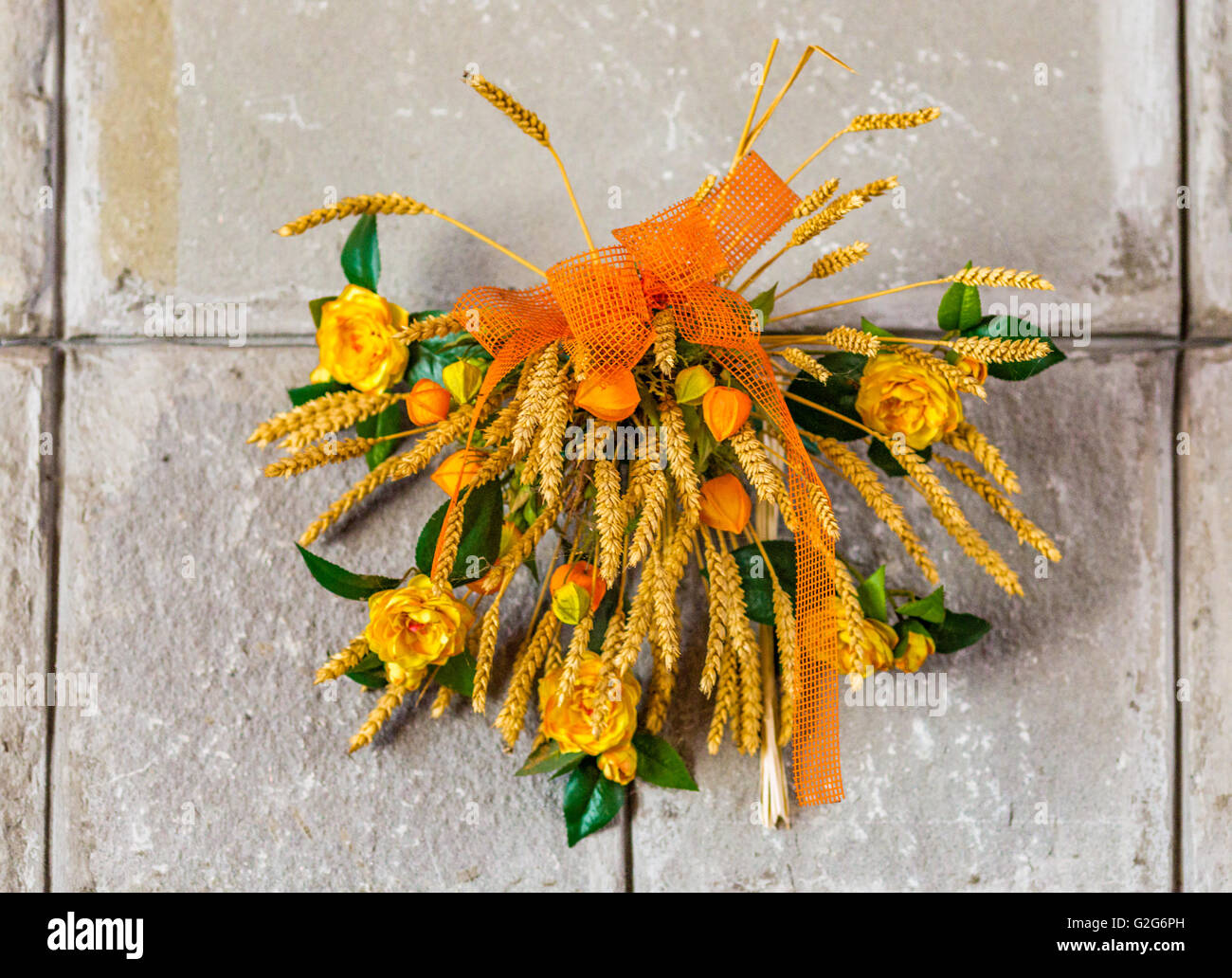 floral decoration with yellow roses, green leaves and blonde ears of ...