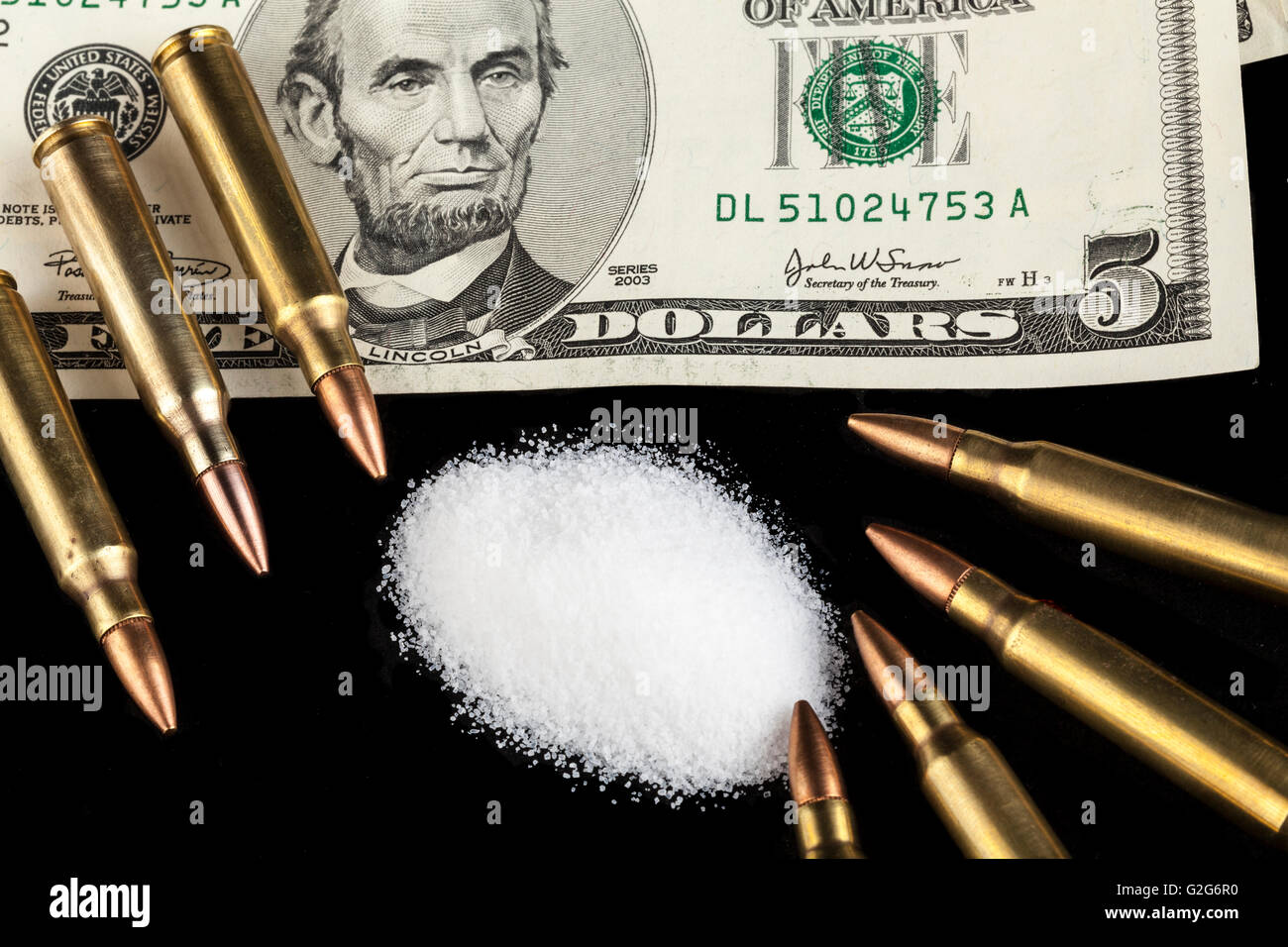 bullets with dollar banknotes with white drug powder on black ...