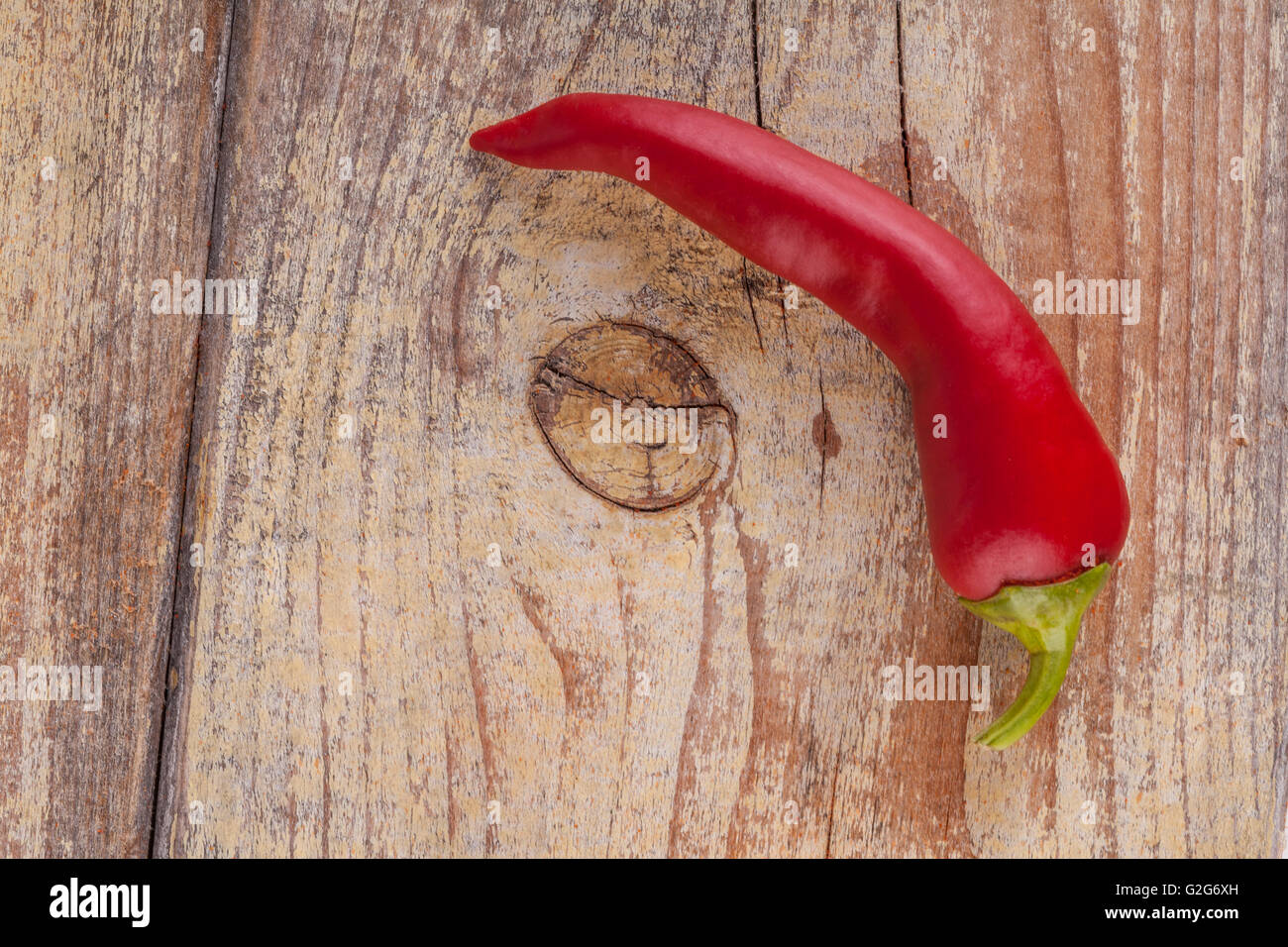 Single Red chili paper on old brown wood table close-up Stock Photo - Alamy
