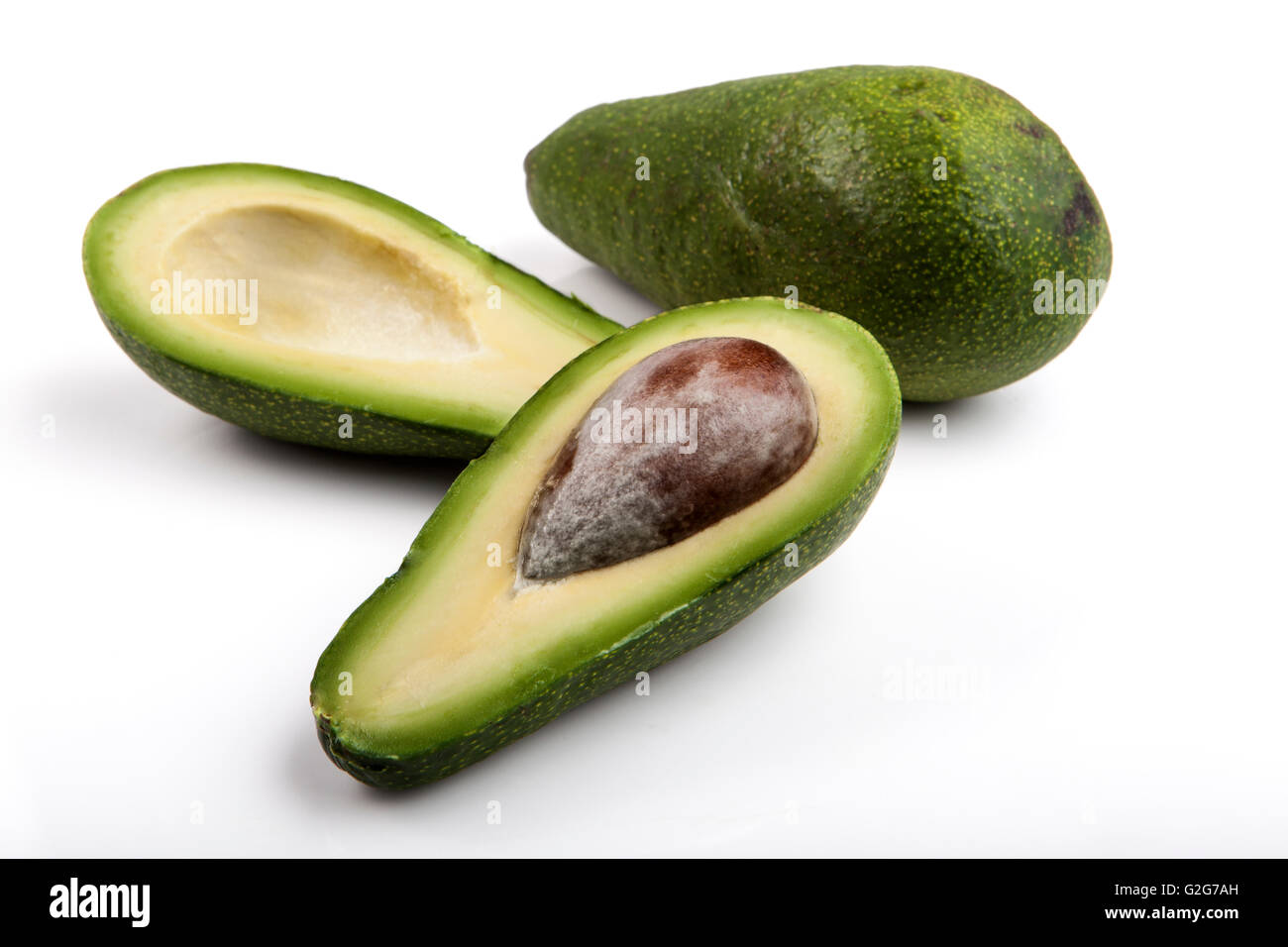 Two avocado one cut in half isolated on white background Stock Photo ...
