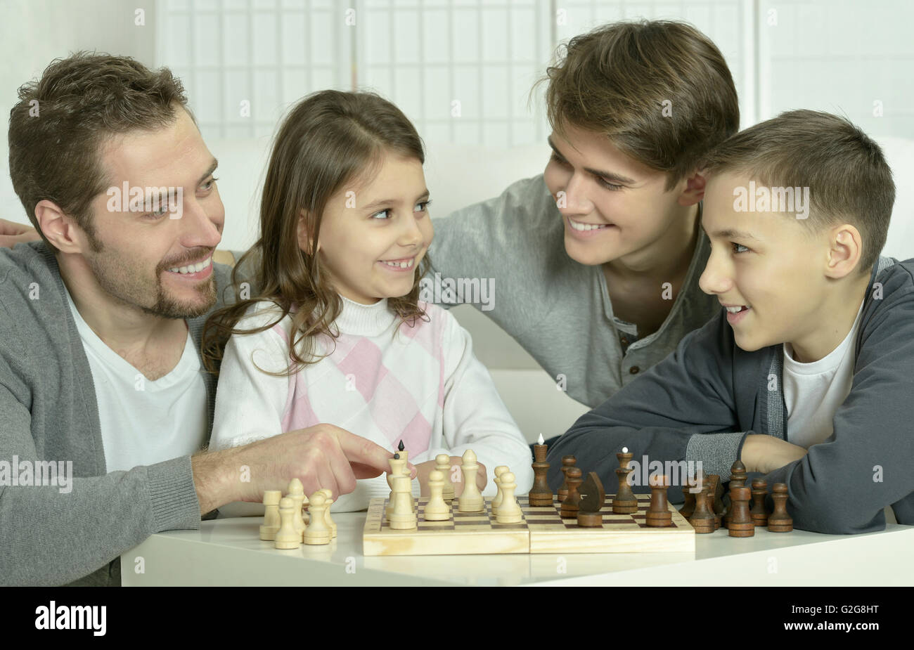 Family playing chess at home Stock Photo - Alamy
