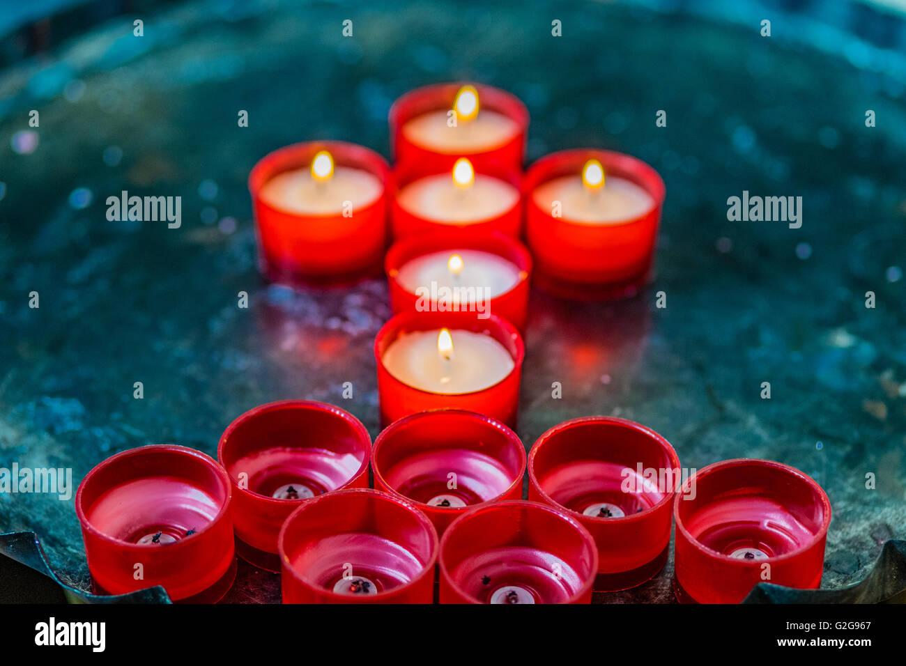 votive candles form the symbol of the Cross Stock Photo - Alamy