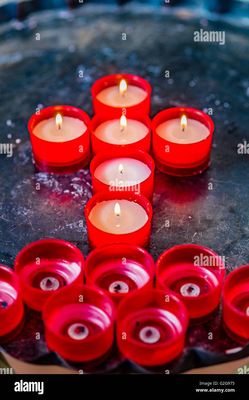 votive candles form the symbol of the Cross Stock Photo - Alamy