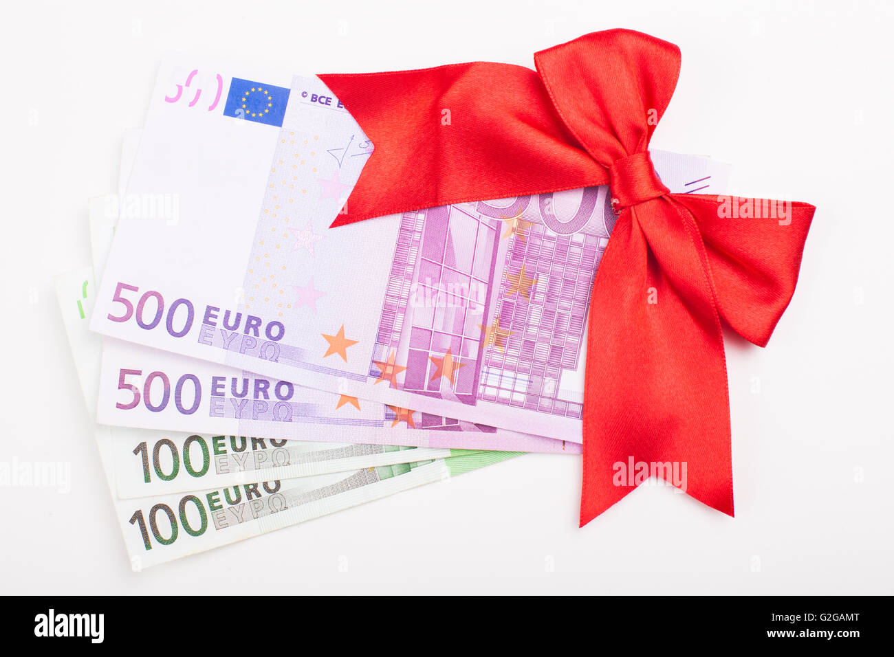 Lot of euro banknotes rapped as a gift with red ribbon isolated on ...