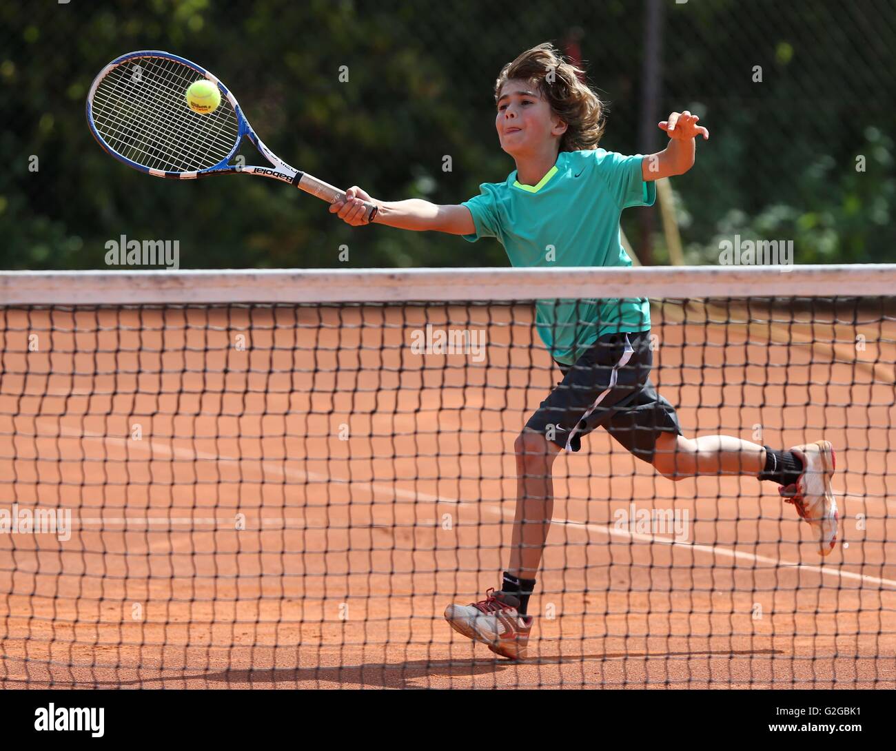 Boy, 10, playing tennis, hitting a forehand volley, Munich, Upper ...