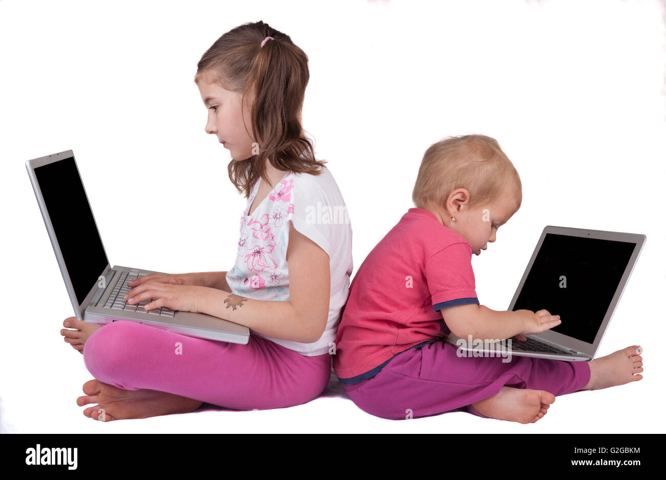 Two girls with two silver color laptops isolated on white backgriund ...