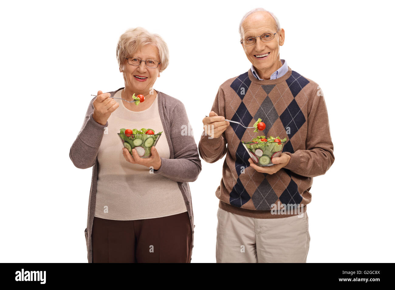 Elderly couple eating salads and looking at the camera isolated on ...