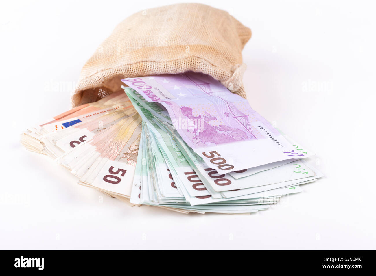 A bag full with euro banknotes pouring out isolated on white background ...