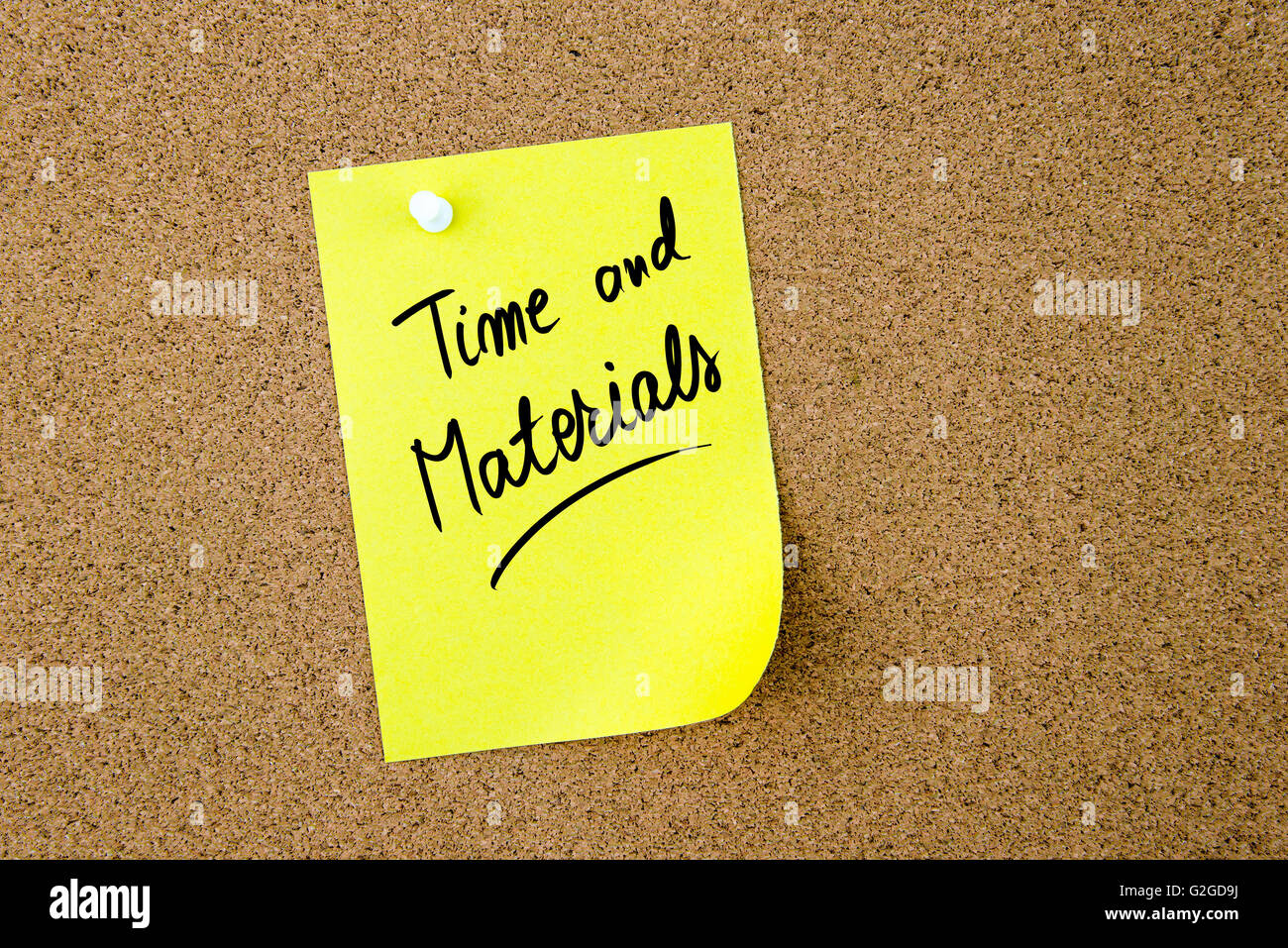 Time and Materials written on yellow paper note pinned on cork board ...