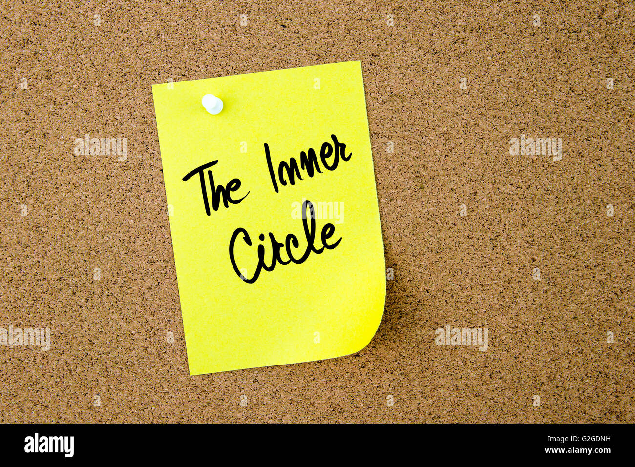 The Inner Circle written on yellow paper note pinned on cork board with ...
