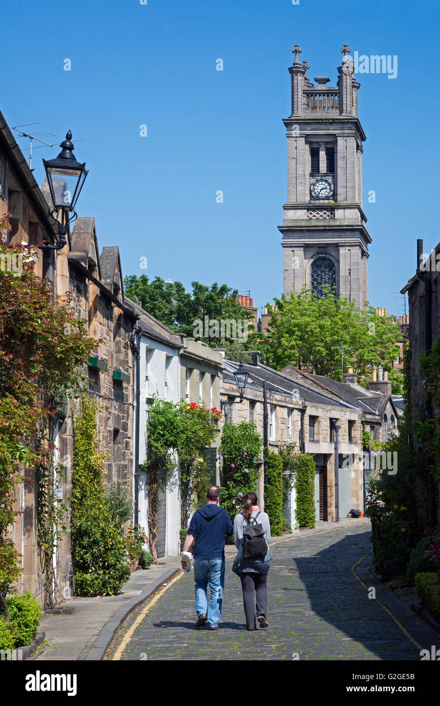 A couple stroll along Circus Lane with the tower of St Stephen's Church ...