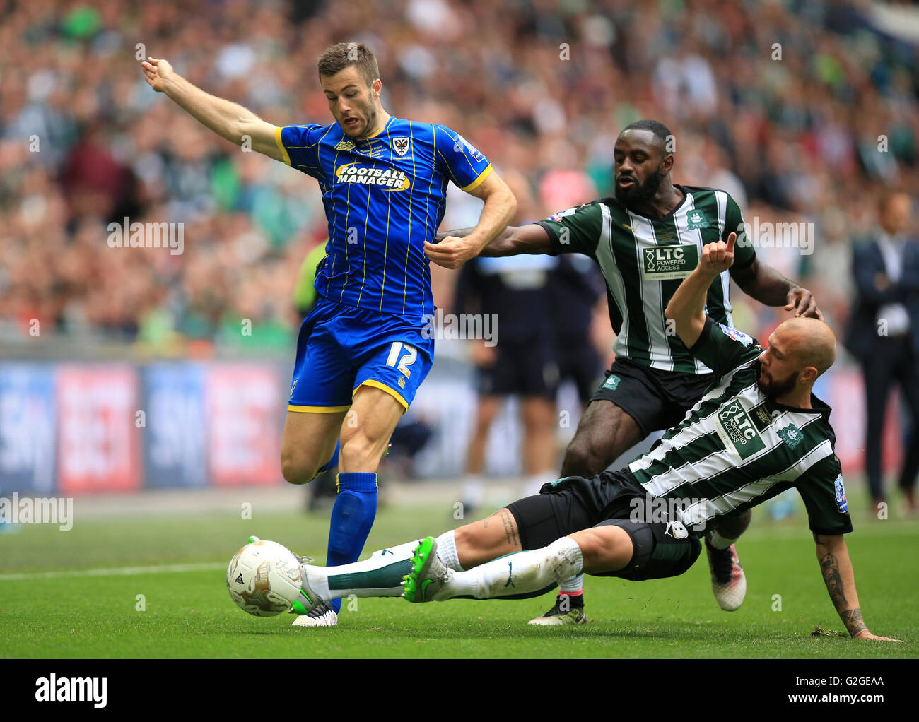 AFC Wimbledon's John Meades (left) and Plymouth Argyle's Jordon Forster ...