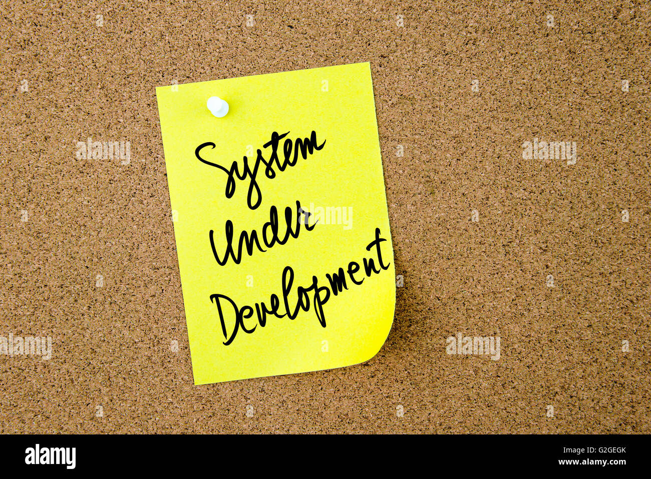 System Under Development written on yellow paper note pinned on cork ...