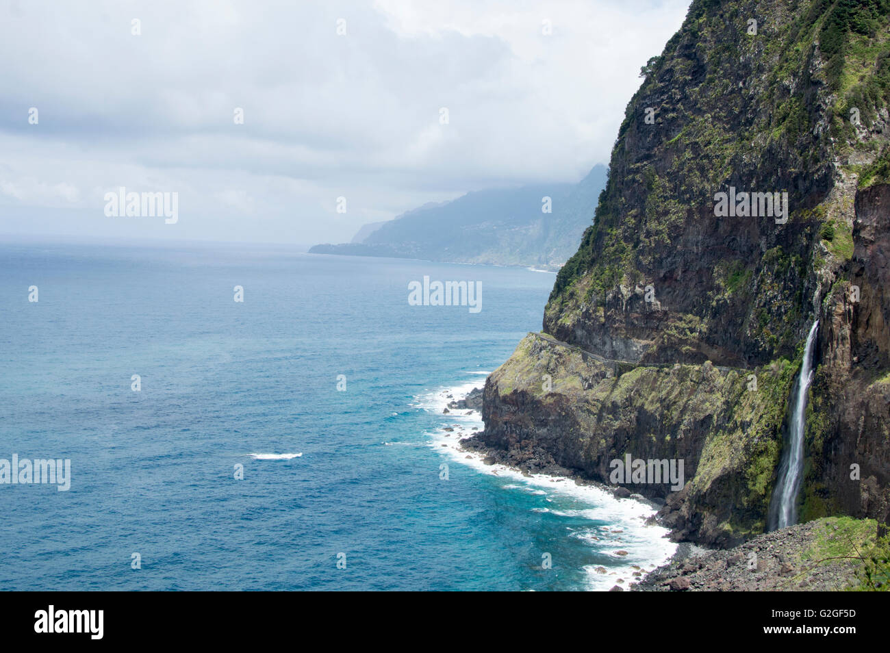 An image of a waterfall flowing into the atlantic ocean from the cliffs ...