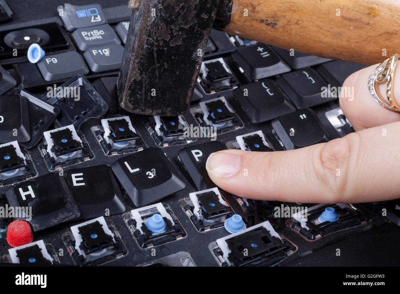 Woman finger on the help keys of broken keyboard with hammer in the ...