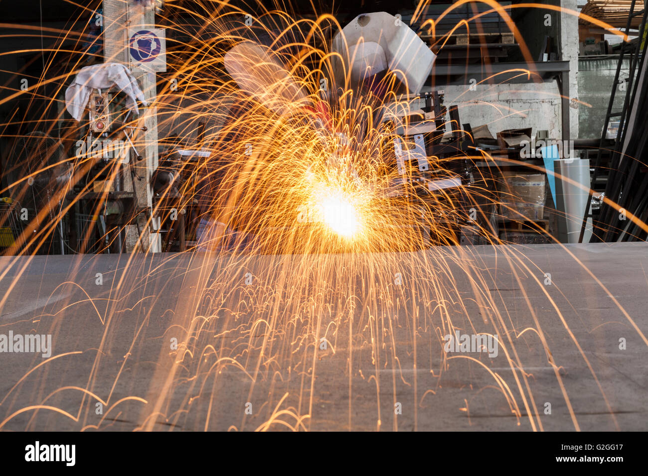 Worker Grinding metal in a workshop with sparks flying Stock Photo - Alamy