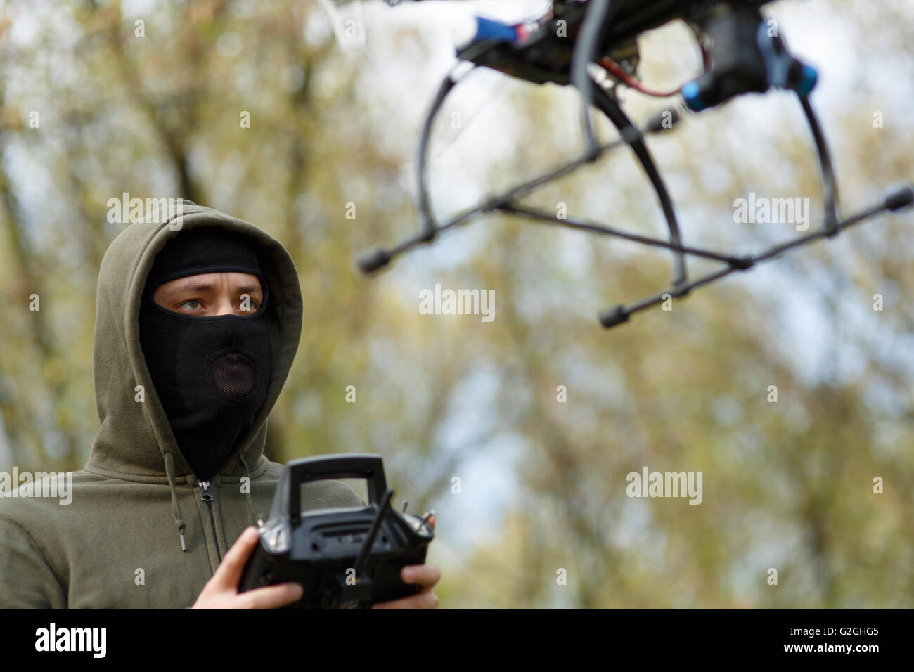 Man in mask operating a drone with remote control Stock Photo - Alamy