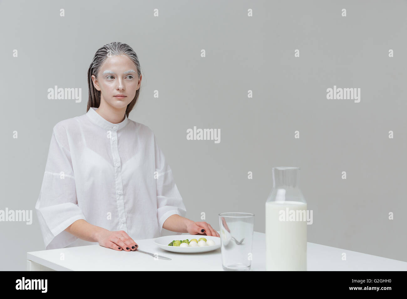 Mystical alien future woman sitting at the table with food and drink ...